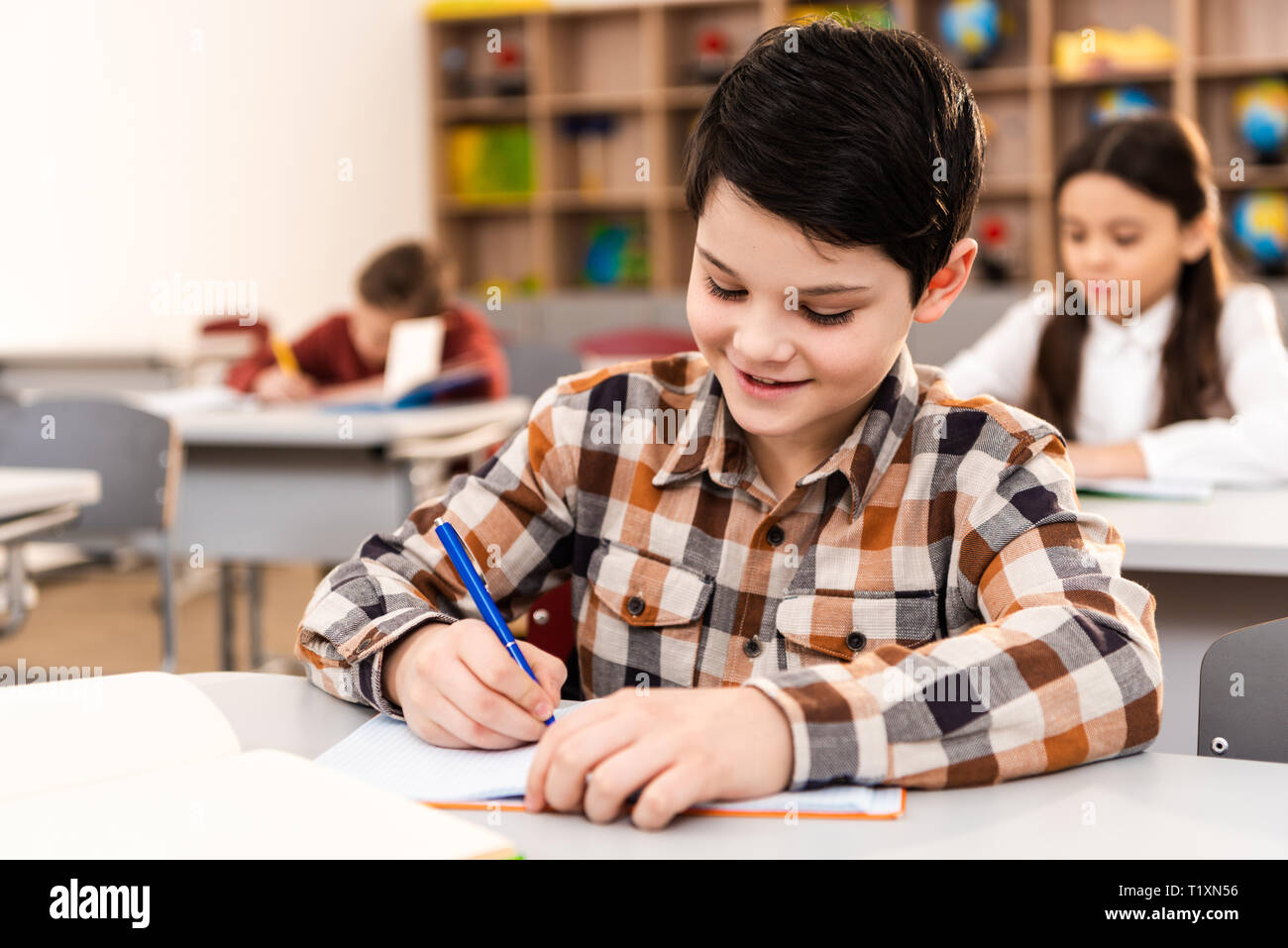 Girl writing during lesson hi-res stock photography and images - Alamy