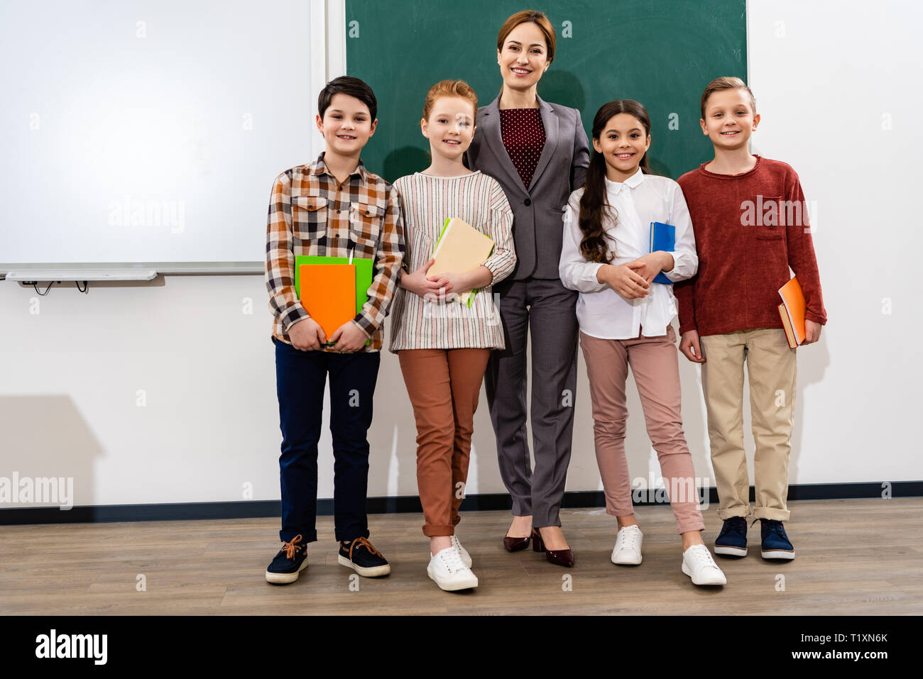 Children standing front blackboard hi-res stock photography and images ...