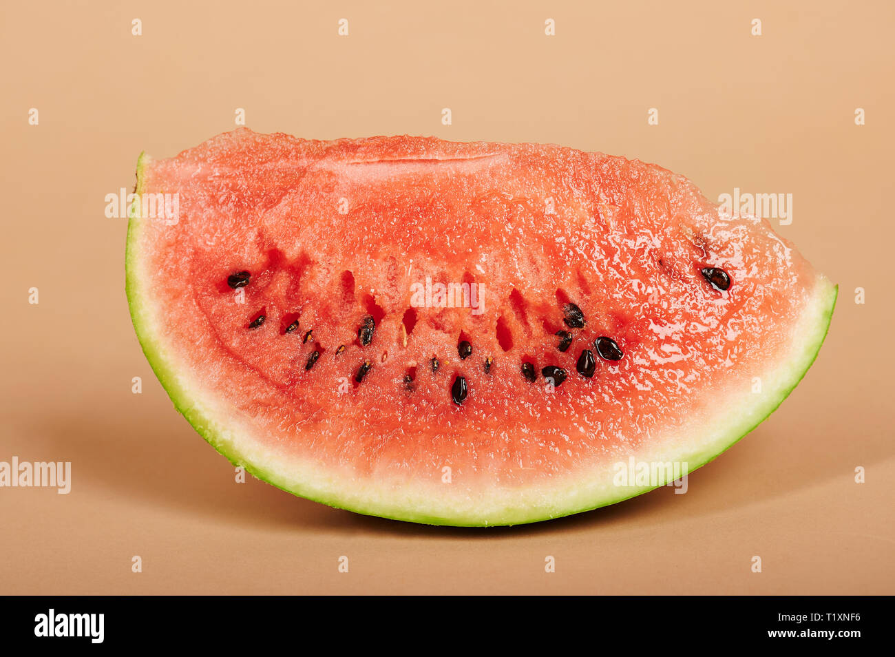 Watermelon slice on brown background close up view Stock Photo - Alamy