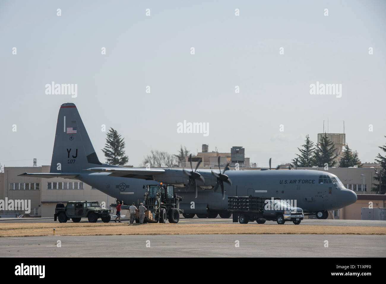 A 374th Operations Group drop zone ground crew prepare to receive a low ...