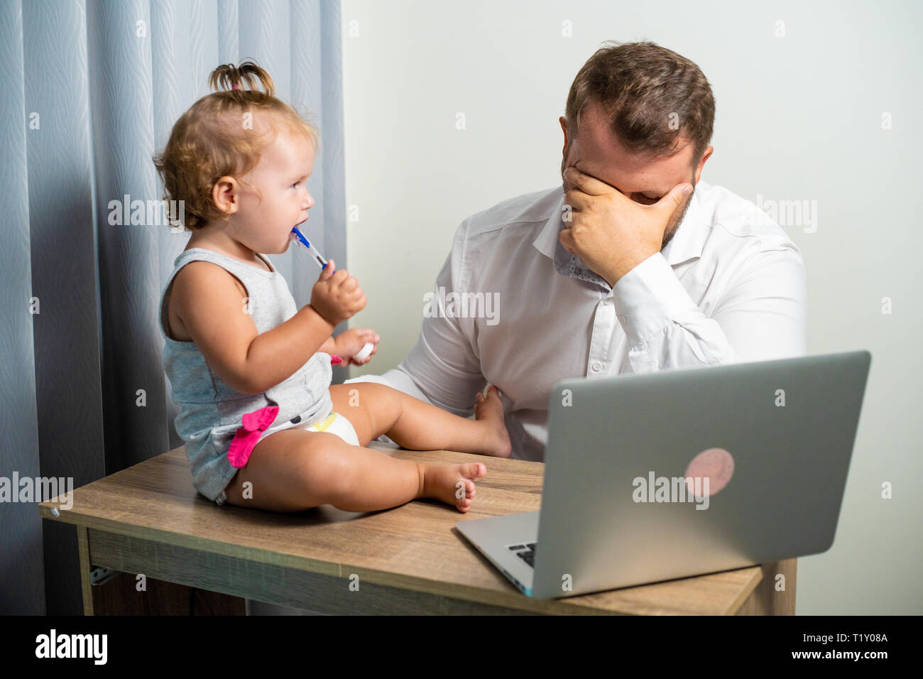 Freelancer work concept. tired dad working at home with a laptop ...