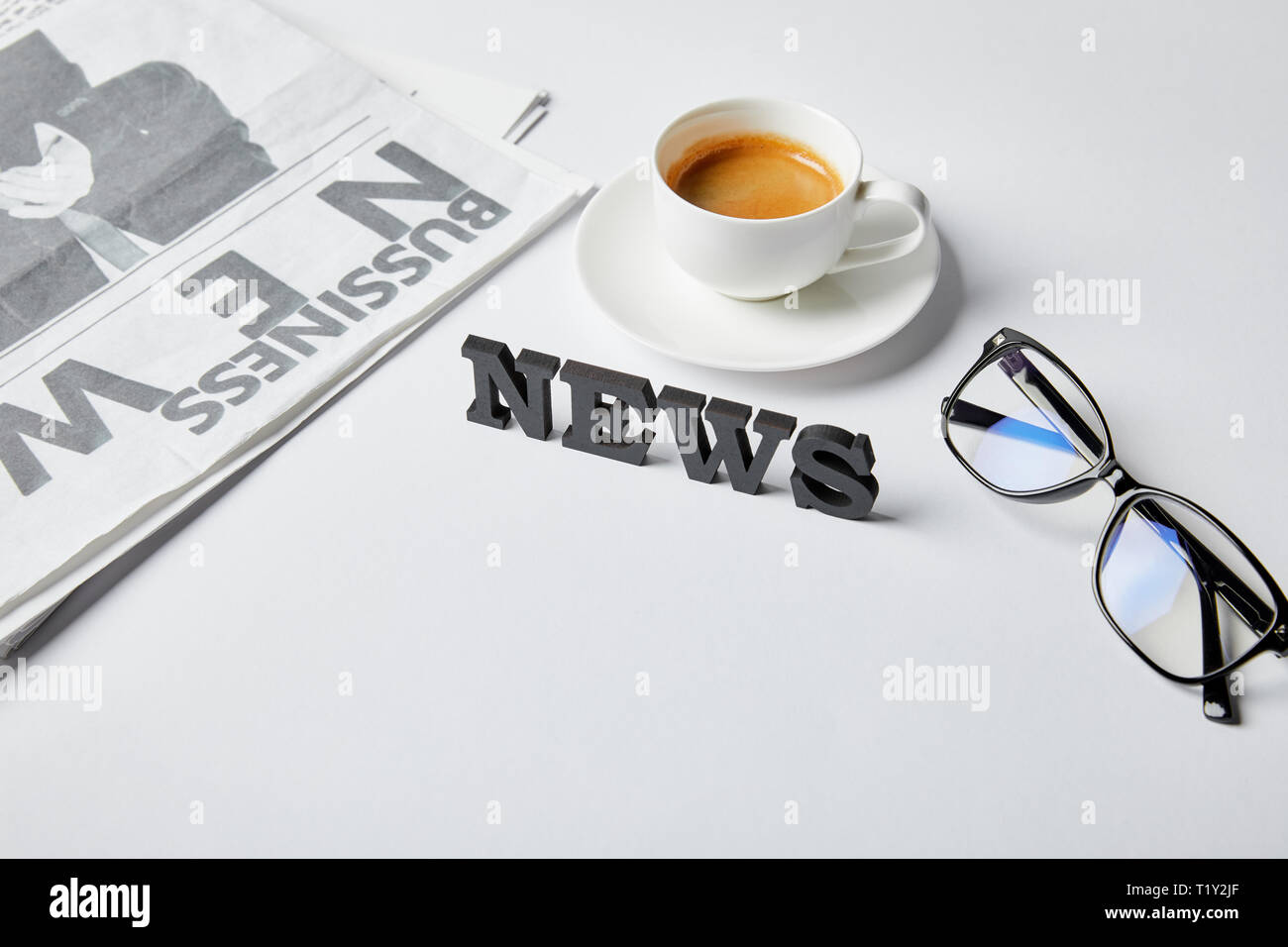 news lettering near cup of coffee, glasses and business newspaper on ...