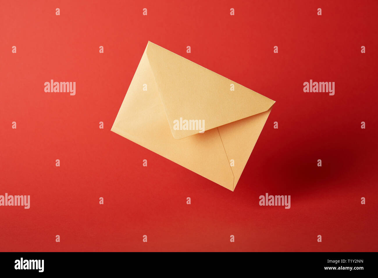 bright, colorful and yellow envelope on red background with copy space ...
