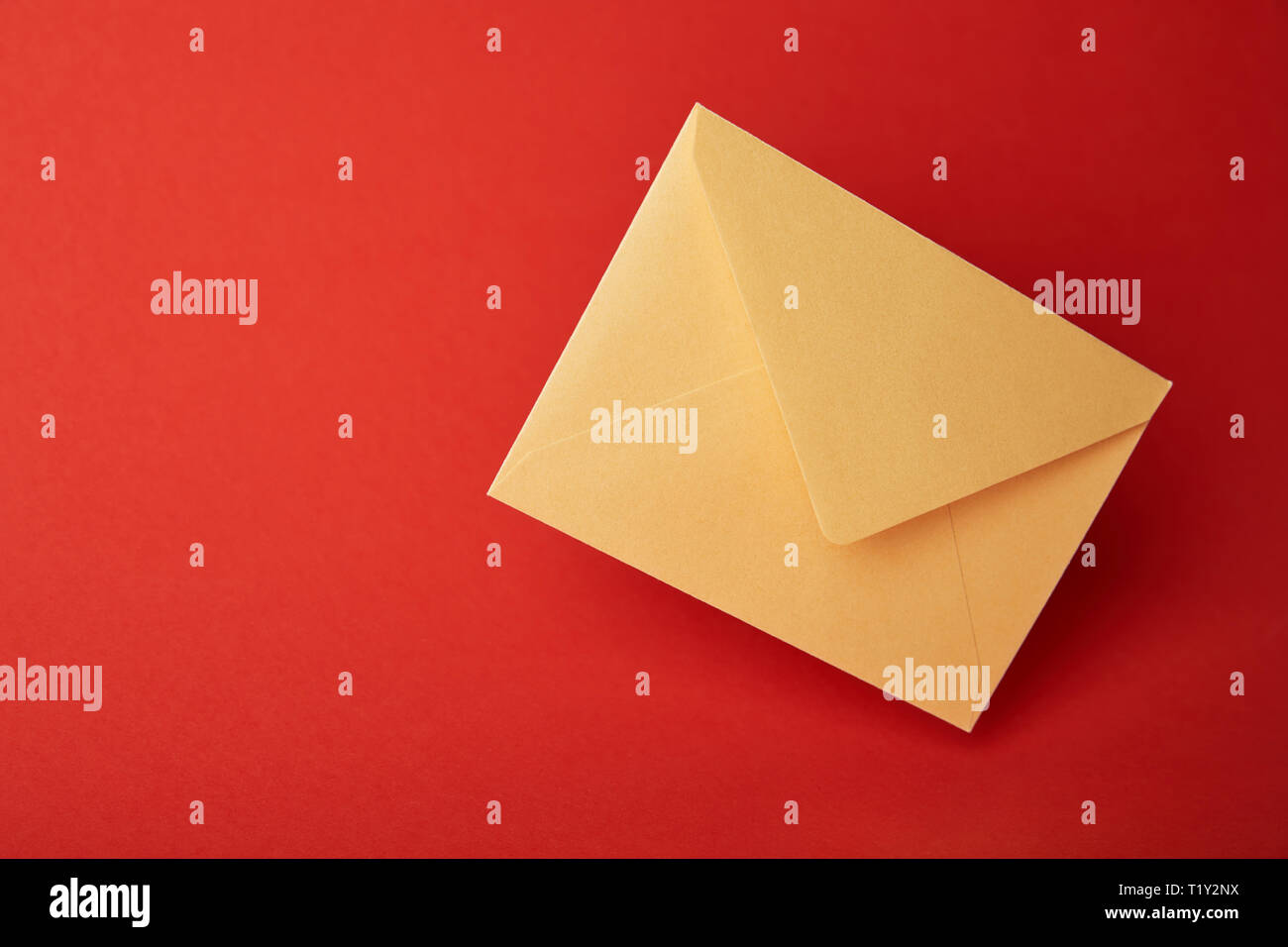 bright, colorful and yellow envelope on red background with copy space ...