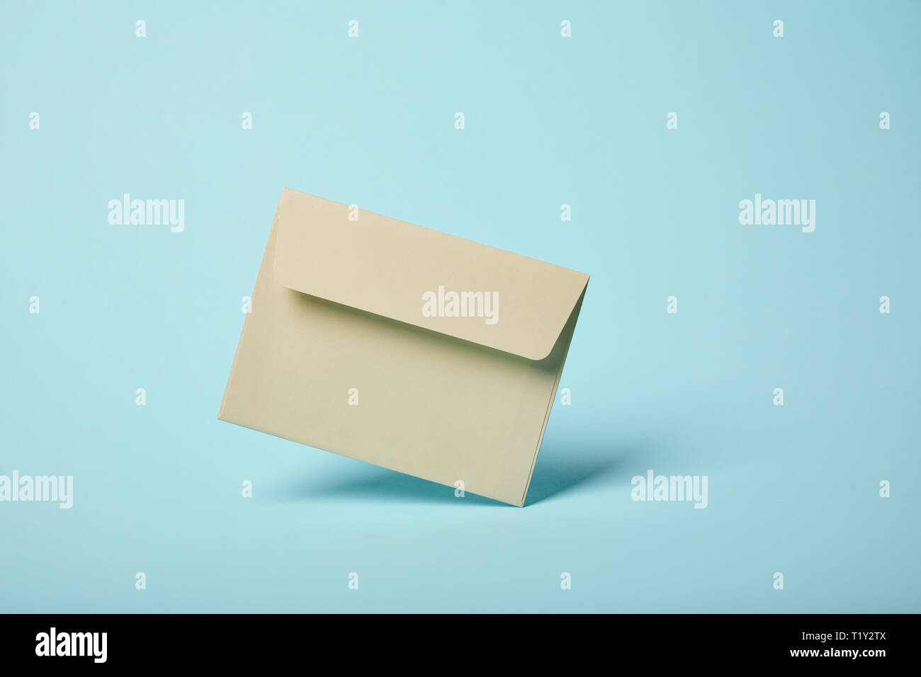 beige and blank envelope on blue background with copy space Stock Photo ...