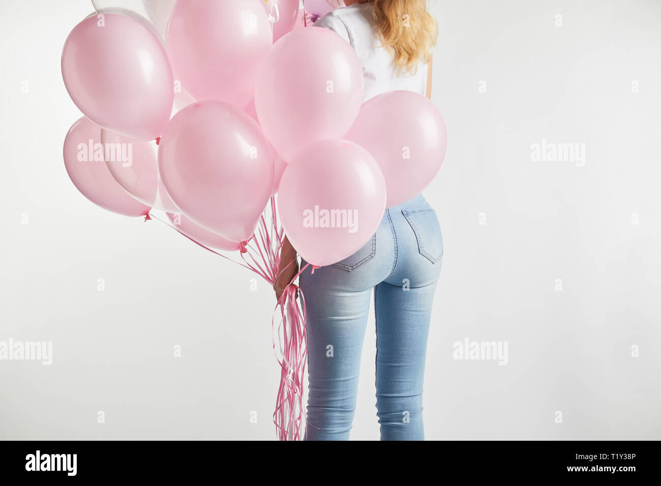 back view of girl holding pink air balloons isolated on white with copy ...
