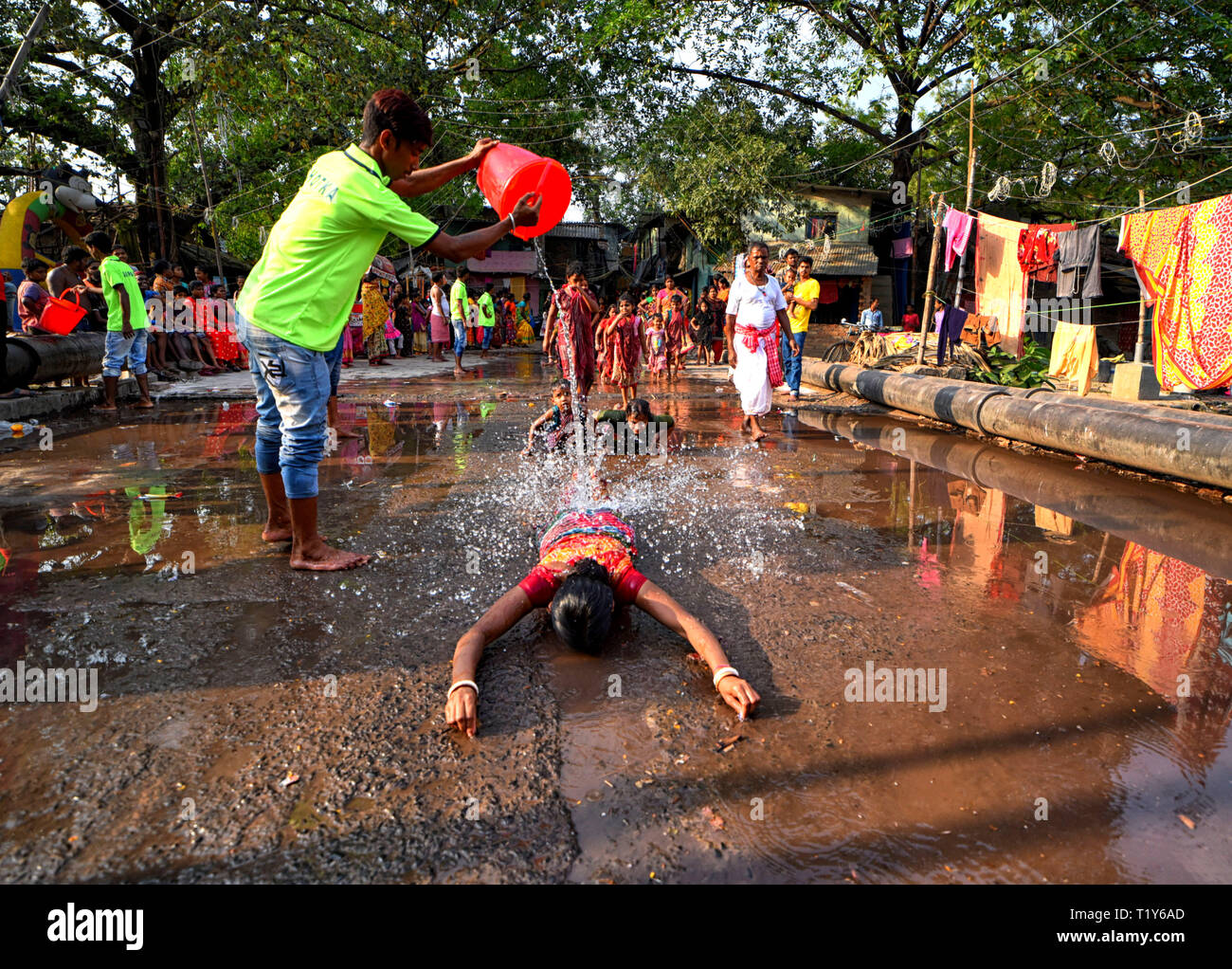 A Hindu woman lies on the ground as a traditional ritual of worship of ...
