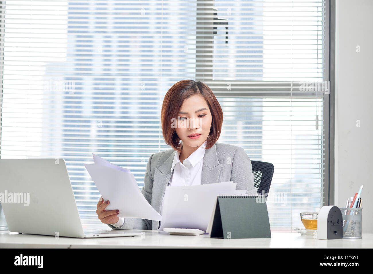 Happy asian woman working in office. Female going through some ...