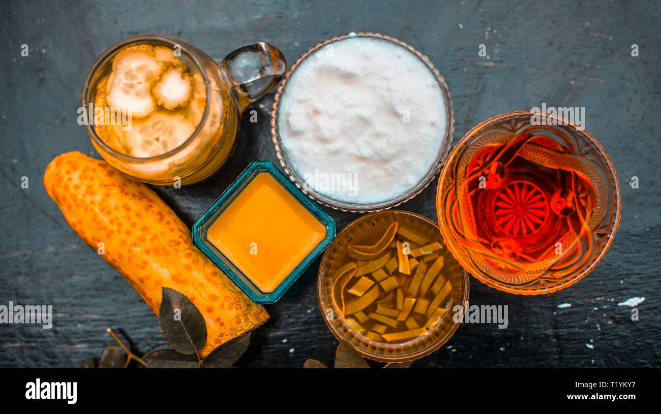 Floral face pack of curd,cucumber, aloe vera gel and honey on wooden ...