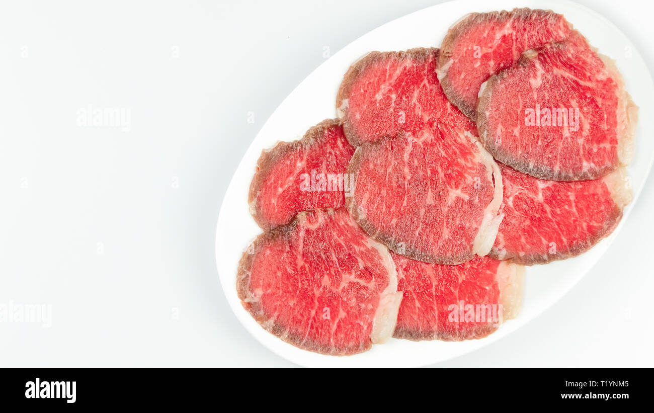 Top view of some raw beef on a plate over white background Stock Photo ...