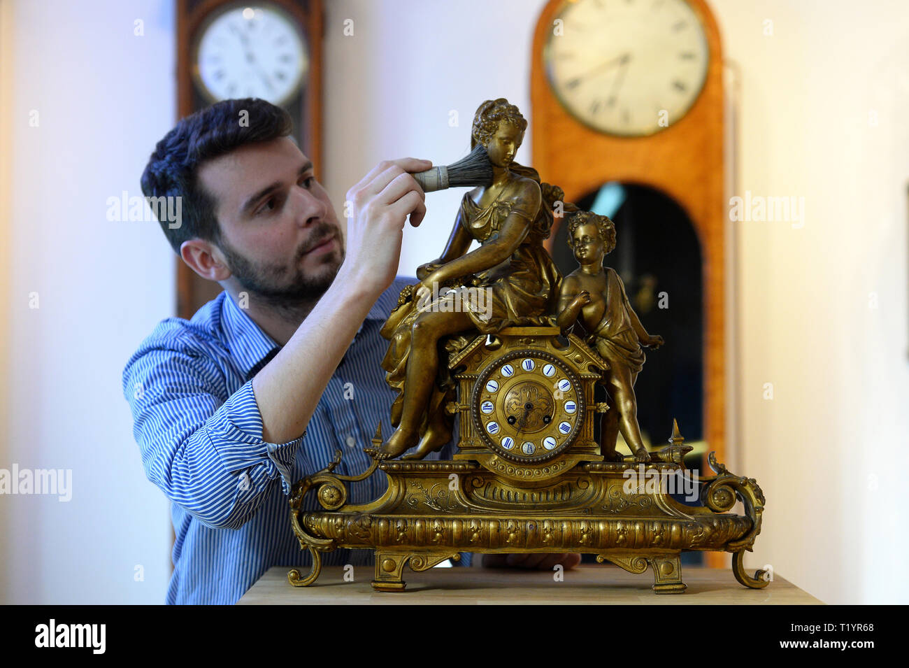 Horologist James Harris dusts a french made mechanical clock at The ...