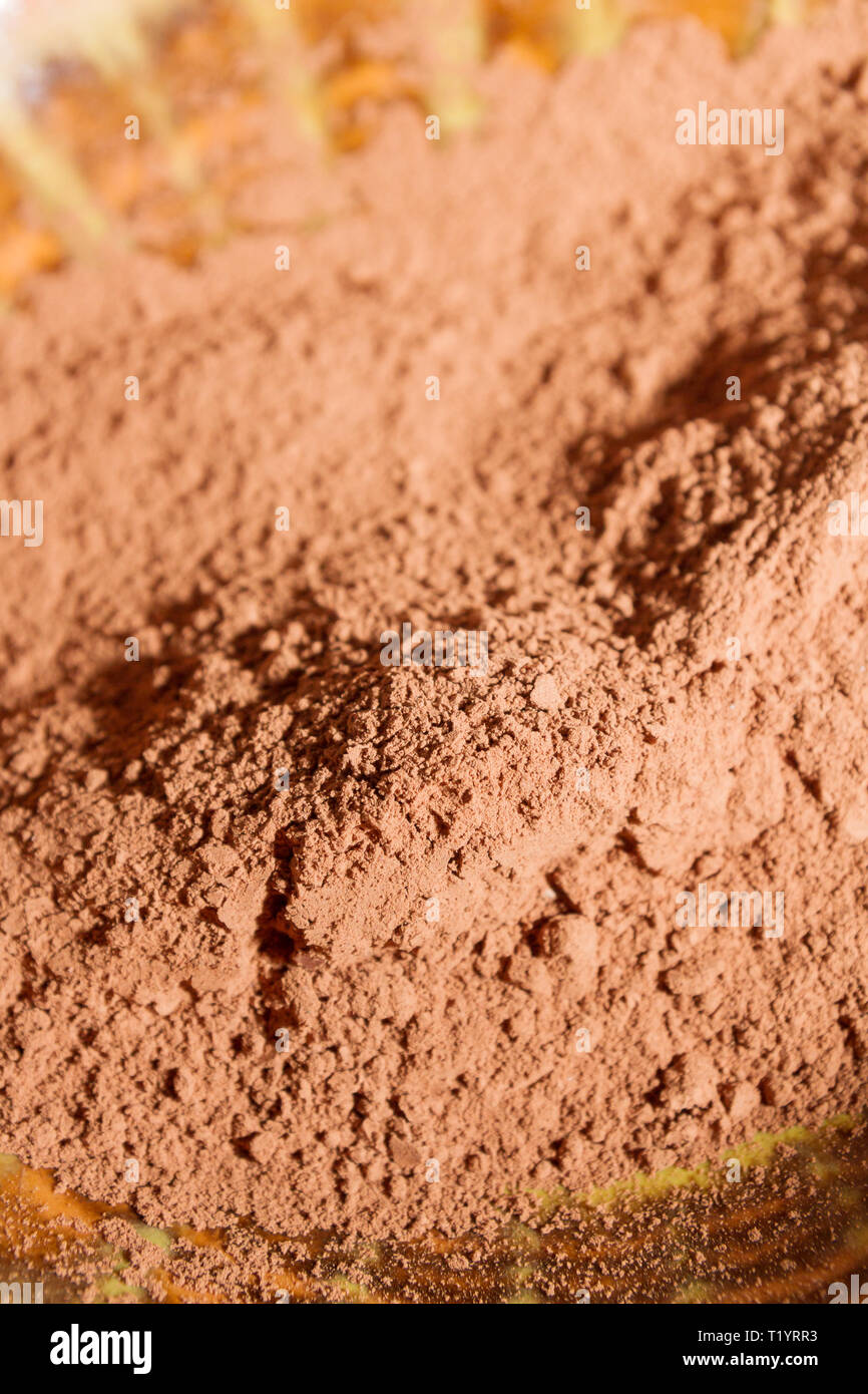 Dry cocoa powder poured into a brown ceramic plate Stock Photo - Alamy