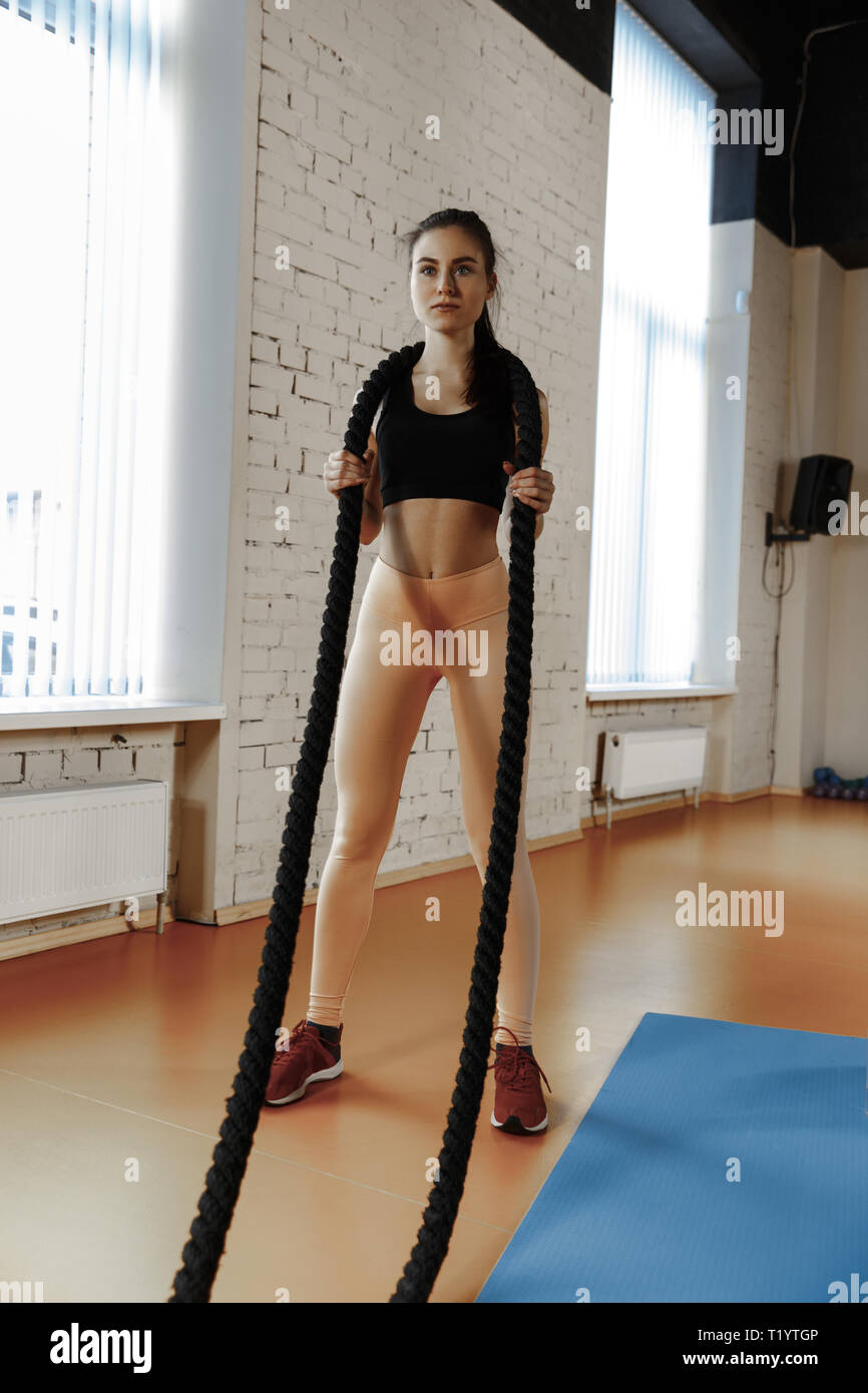 Woman with battle ropes exercise in the fitness gym. Athlete, sport, rope, training, workout ...