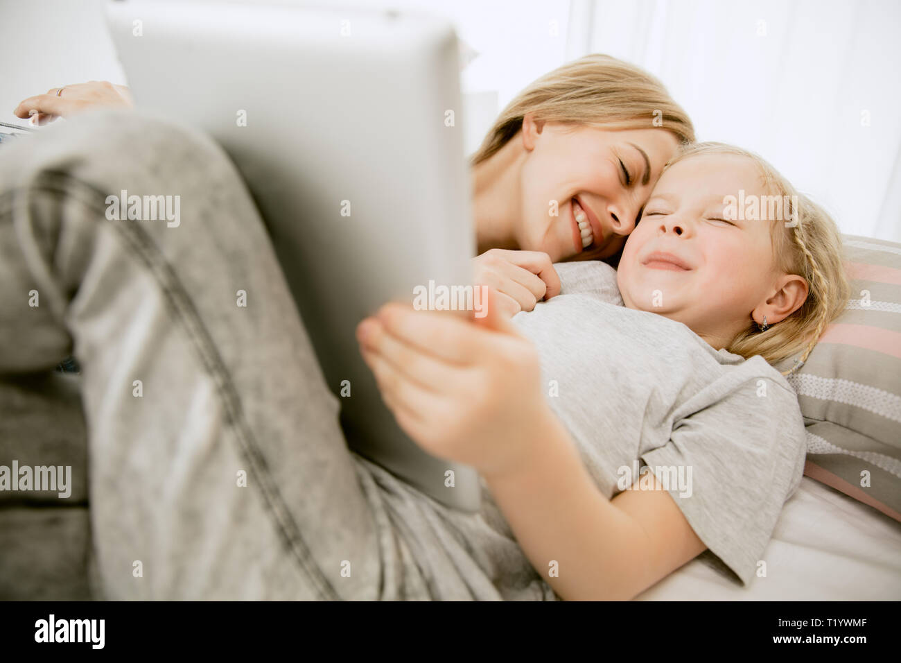 Young mother and her little daughter at home at sunny morning. Soft ...