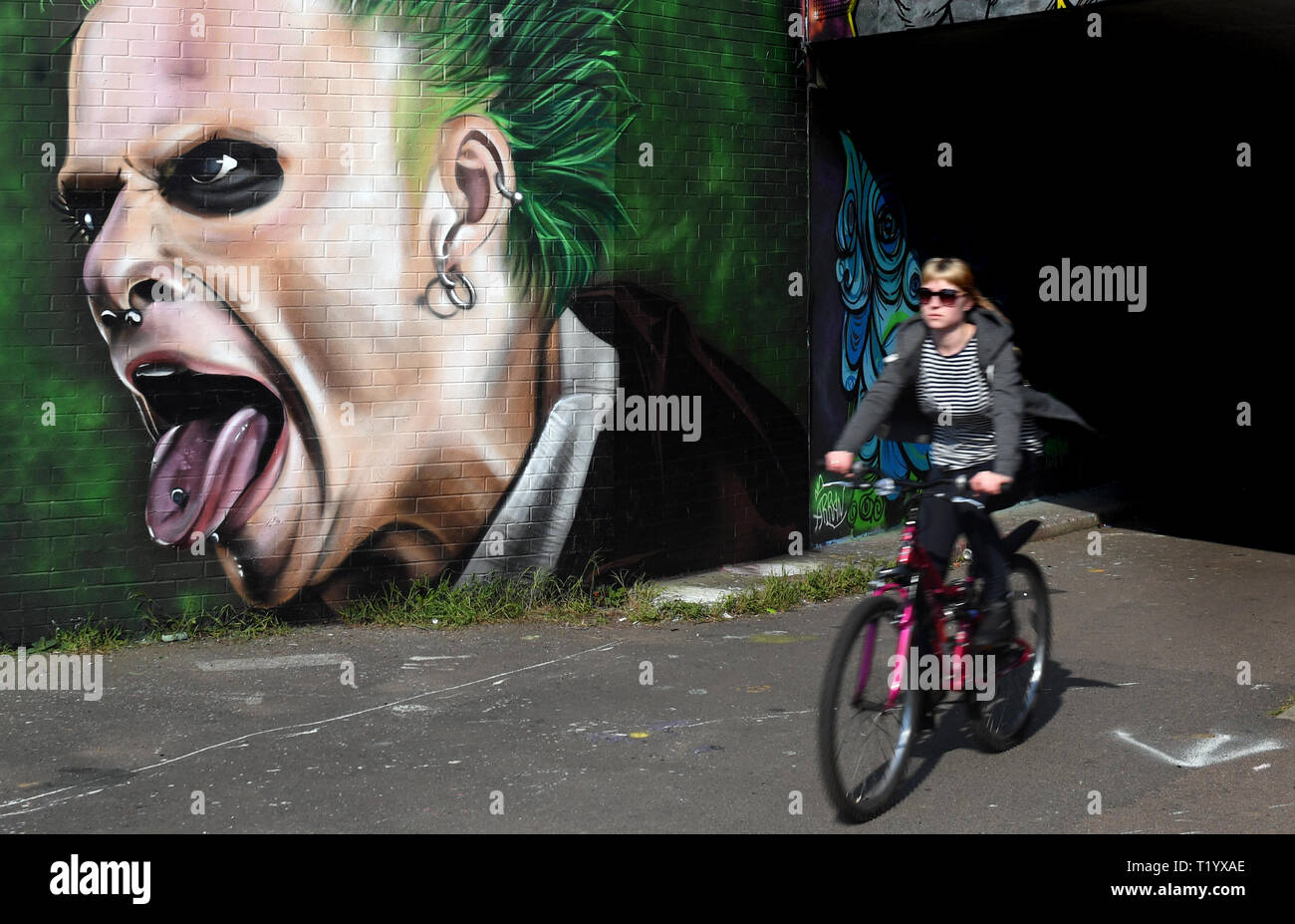 A woman cycles past a mural of Keith Flint in Peterborough ahead of his ...