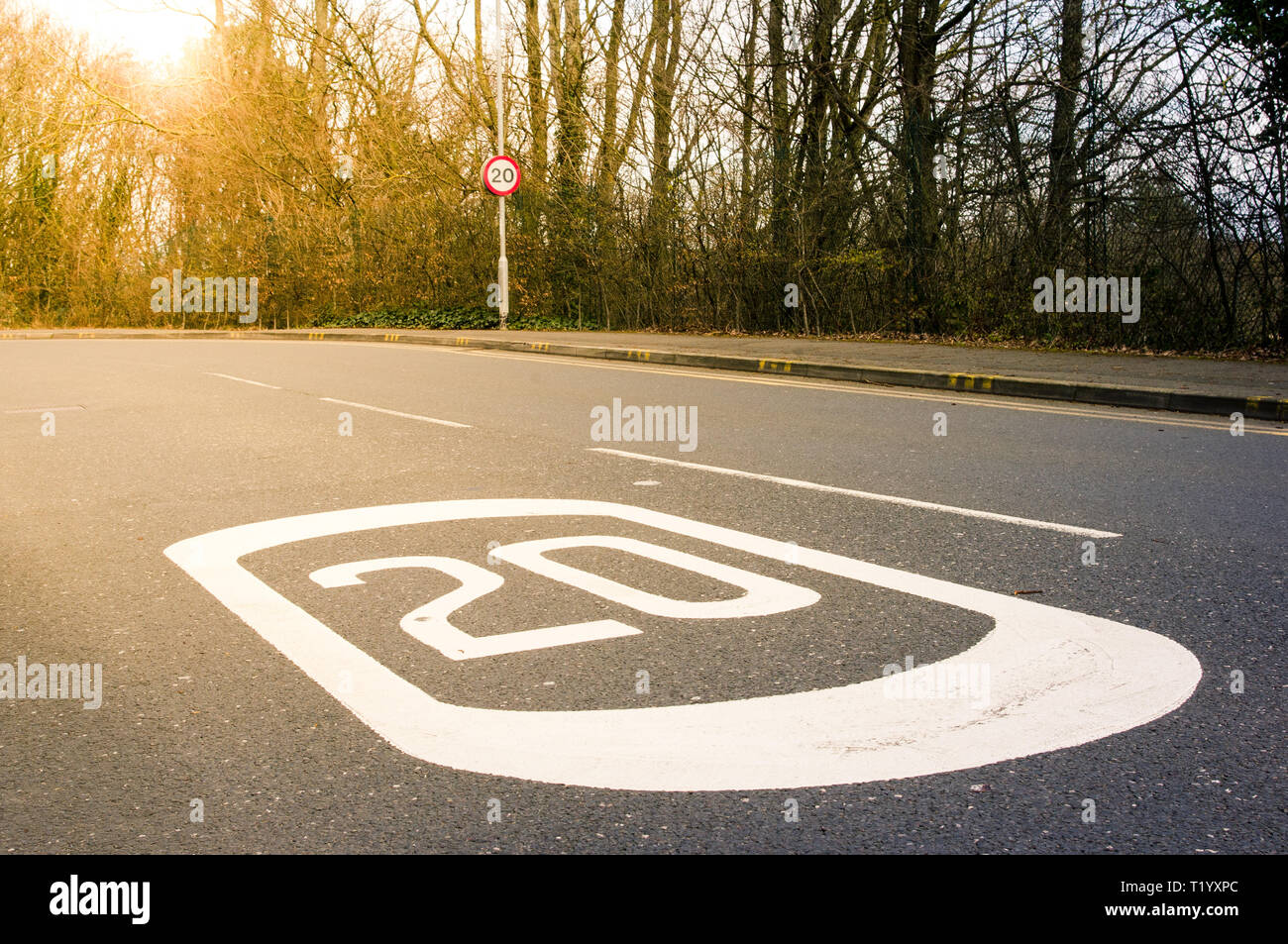 20 mph sign post and painted on the road Stock Photo - Alamy