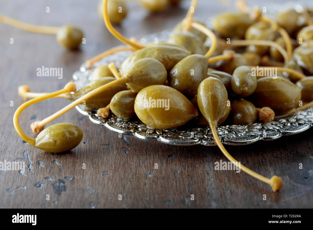 Pickled caper berries in metal dish . Edible fruits of Capparis ...