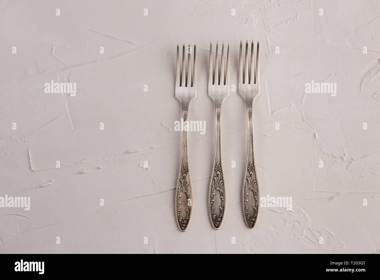 Very old rusty vintage set of three silver forks isolated on a white ...