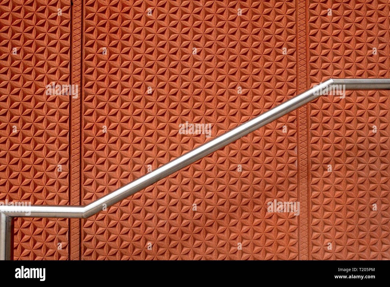 stainless steel handrail or Banister on steps the Cladded wall of ...