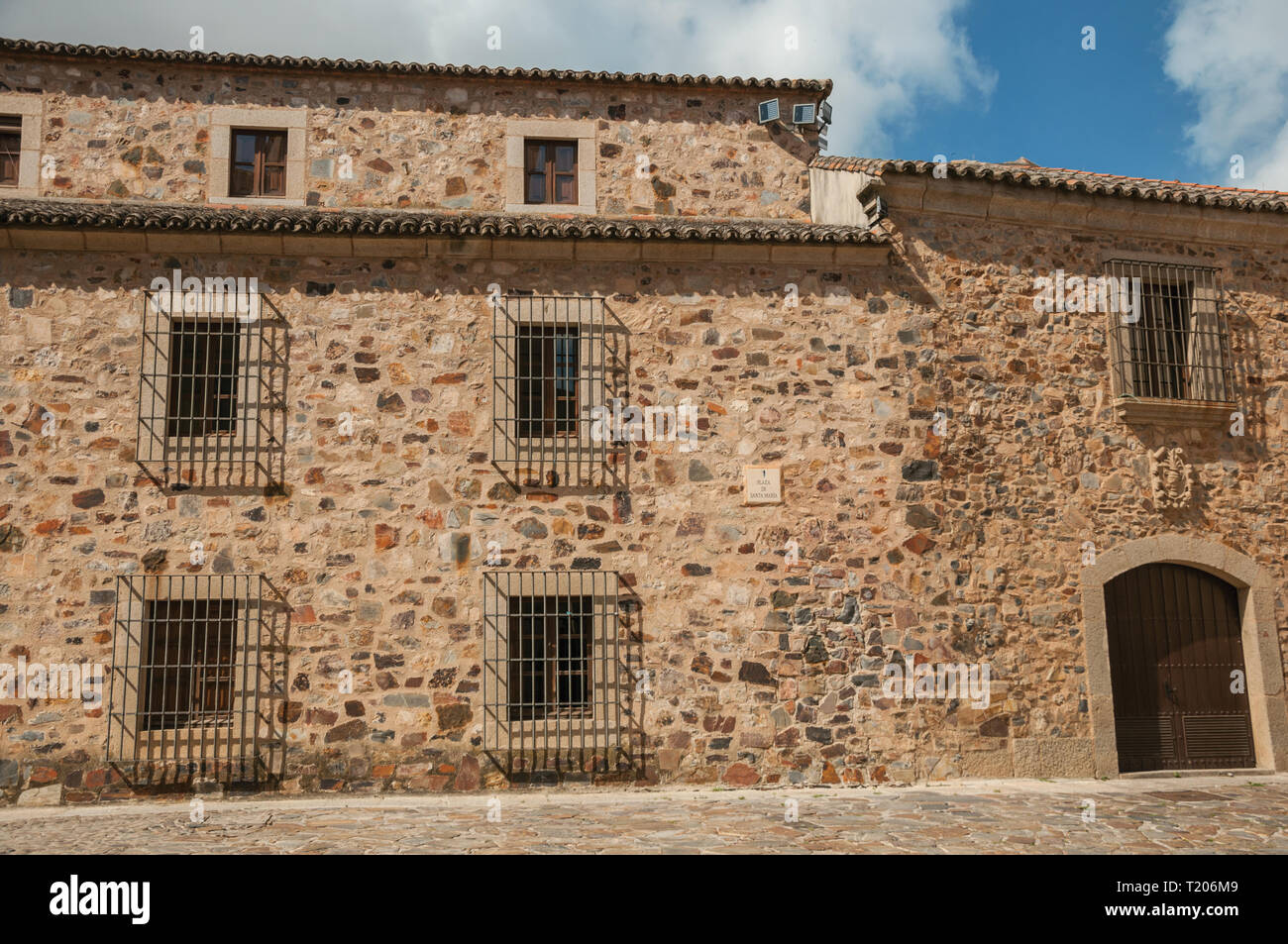 Medieval building facade, with wooden door and barred windows at ...