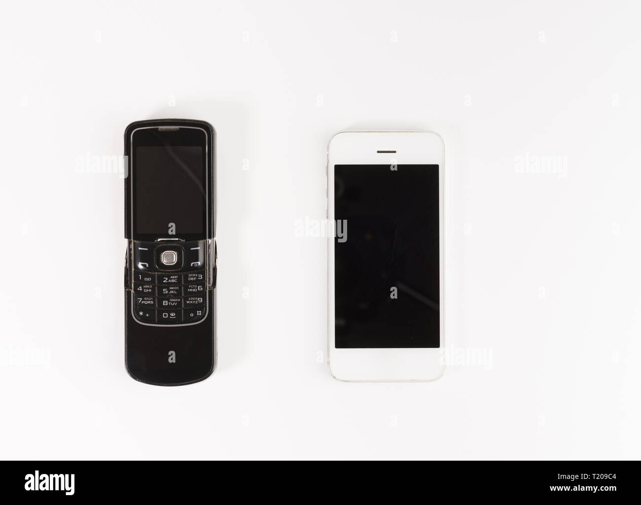 Smartphone and old technology telephone isolated on white background ...