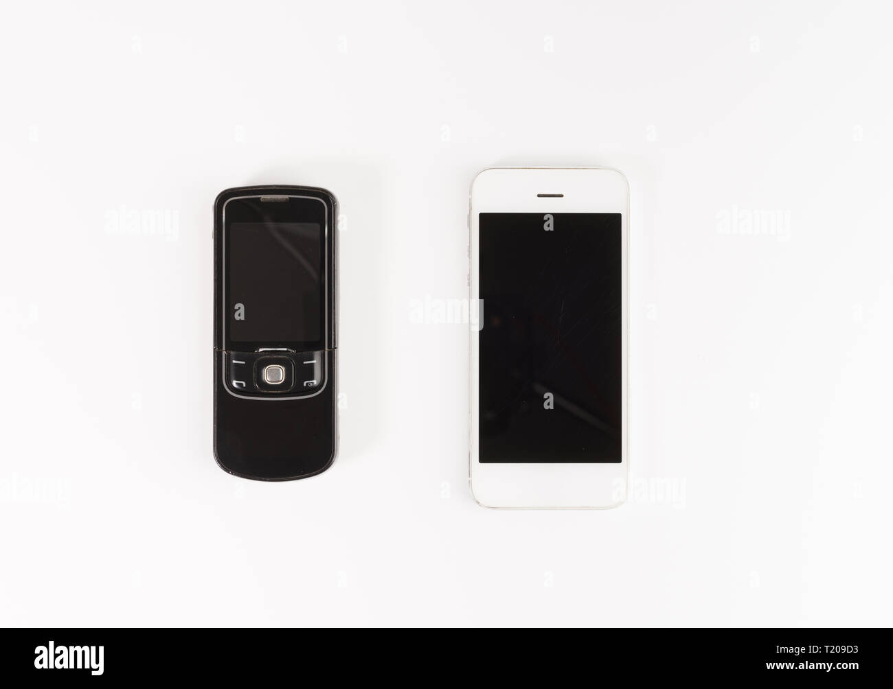 Smartphone and old technology telephone isolated on white background ...