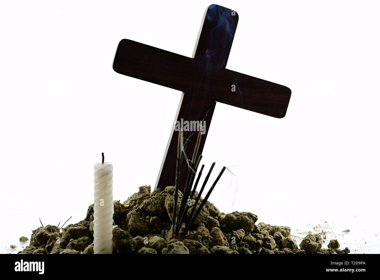 Burning candle under Jesus cross in cemetery isolated against white ...