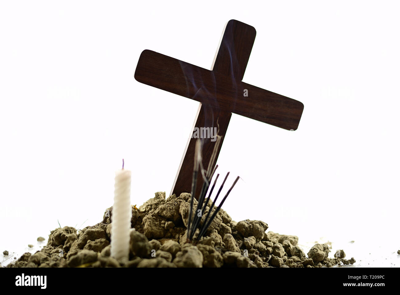Burning candle under Jesus cross in cemetery isolated against white ...