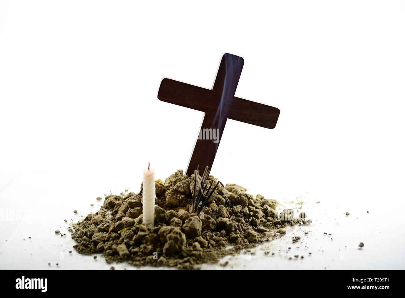Burning candle under Jesus cross in cemetery isolated against white ...
