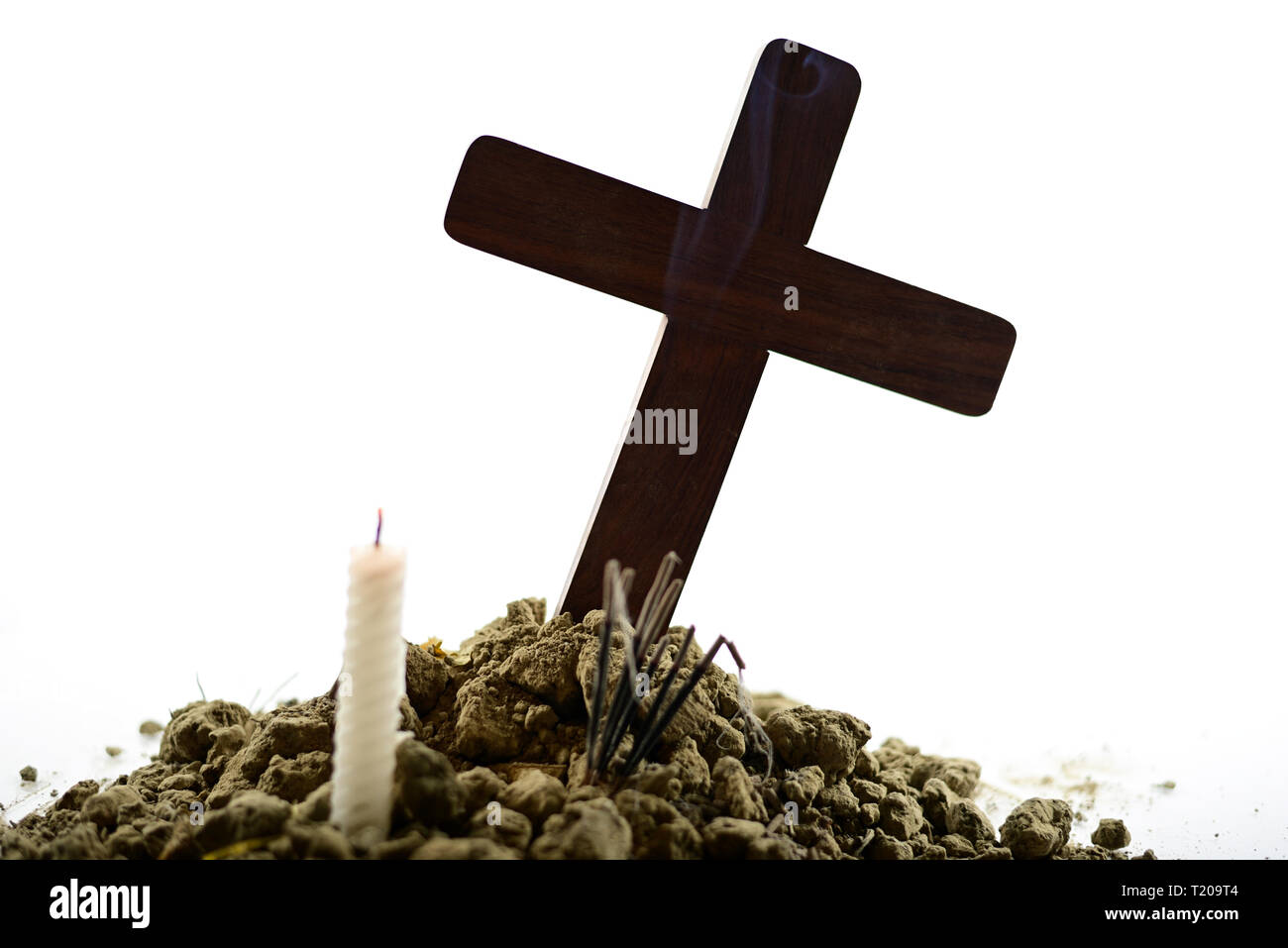 Burning candle under Jesus cross in cemetery isolated against white ...