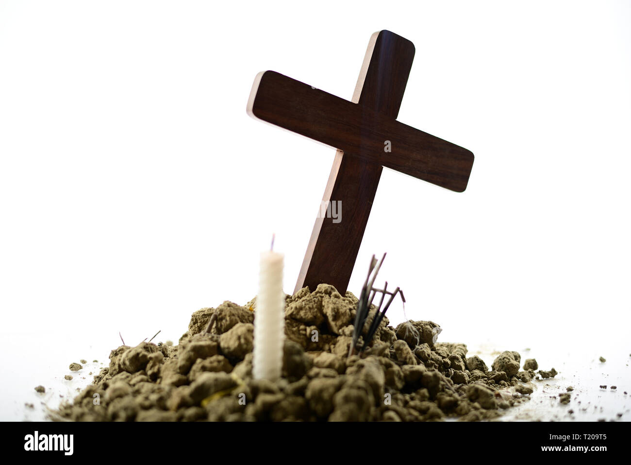 Burning candle under Jesus cross in cemetery isolated against white ...