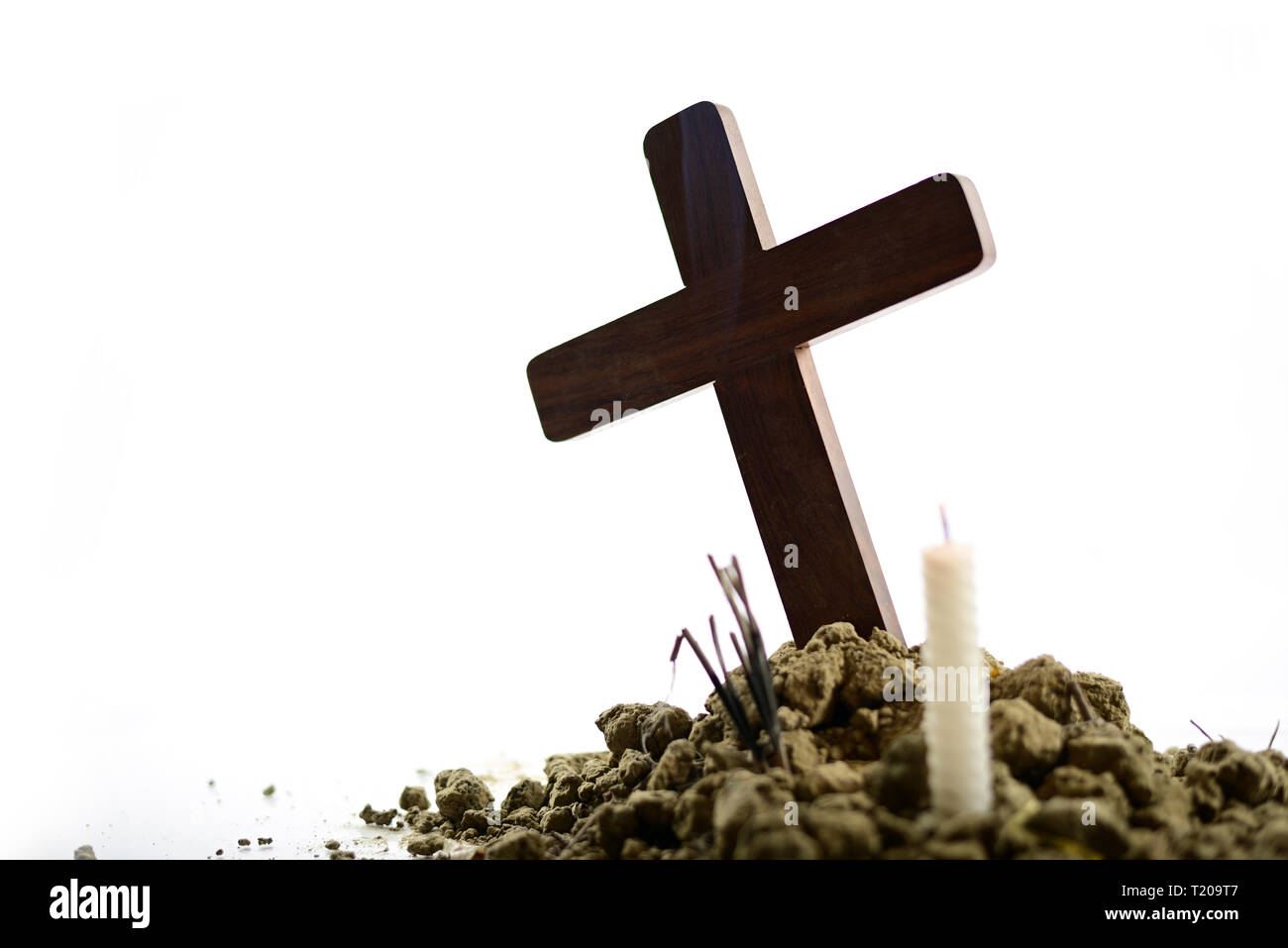 Burning candle under Jesus cross in cemetery isolated against white ...