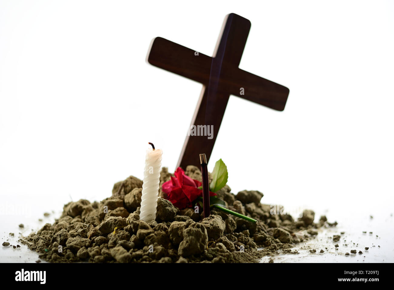 Burning candle under Jesus cross in cemetery isolated against white ...