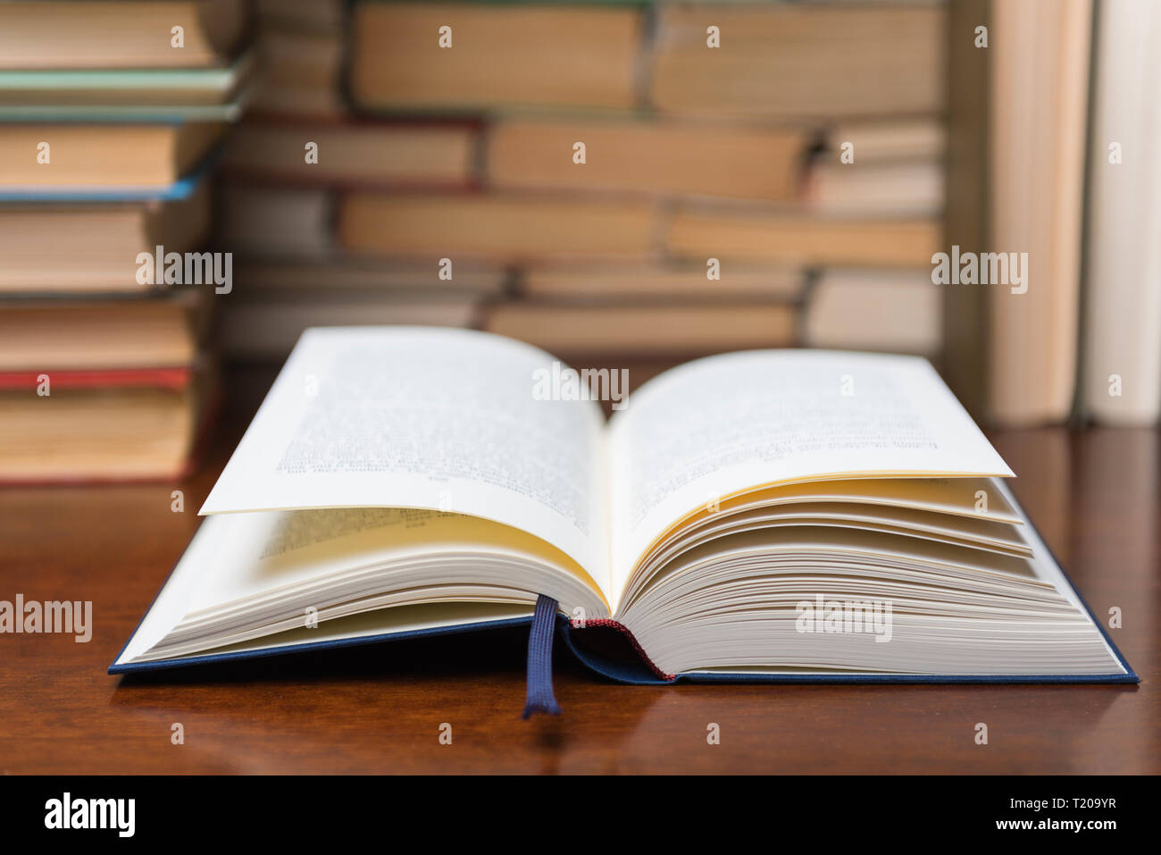 open book on the table, on the background of many books Stock Photo - Alamy