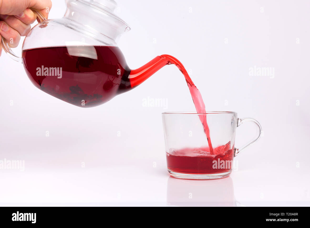 Tea pouring into glass cup isolated on white background Stock Photo - Alamy