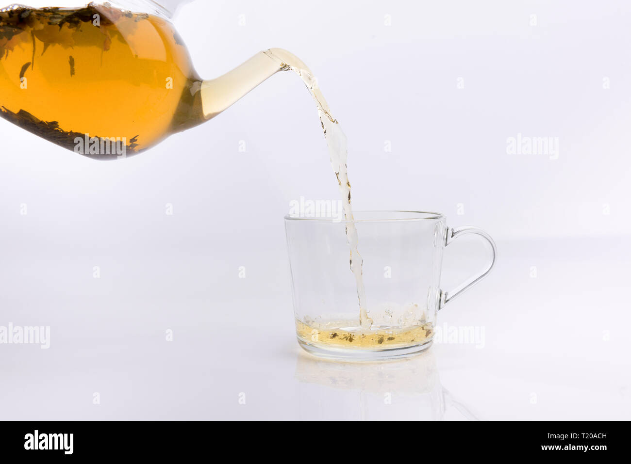 Tea pouring into glass cup isolated on white Stock Photo - Alamy