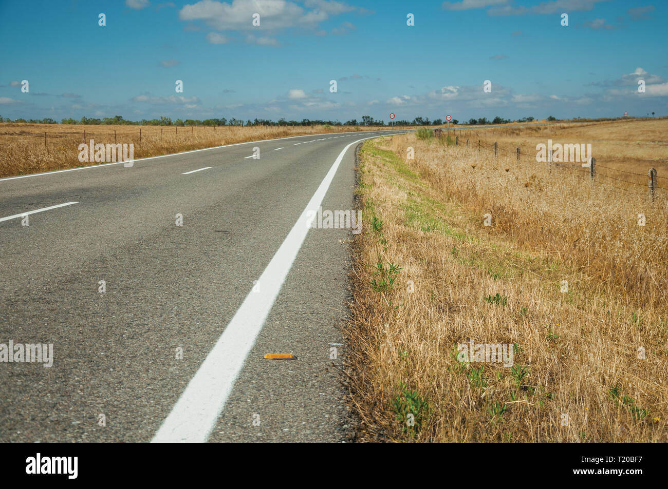 Deserted road through rural landscape with farmed fields near the ...