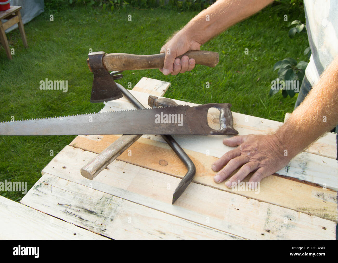 man holding the axe, working with construction tools in his garden ...
