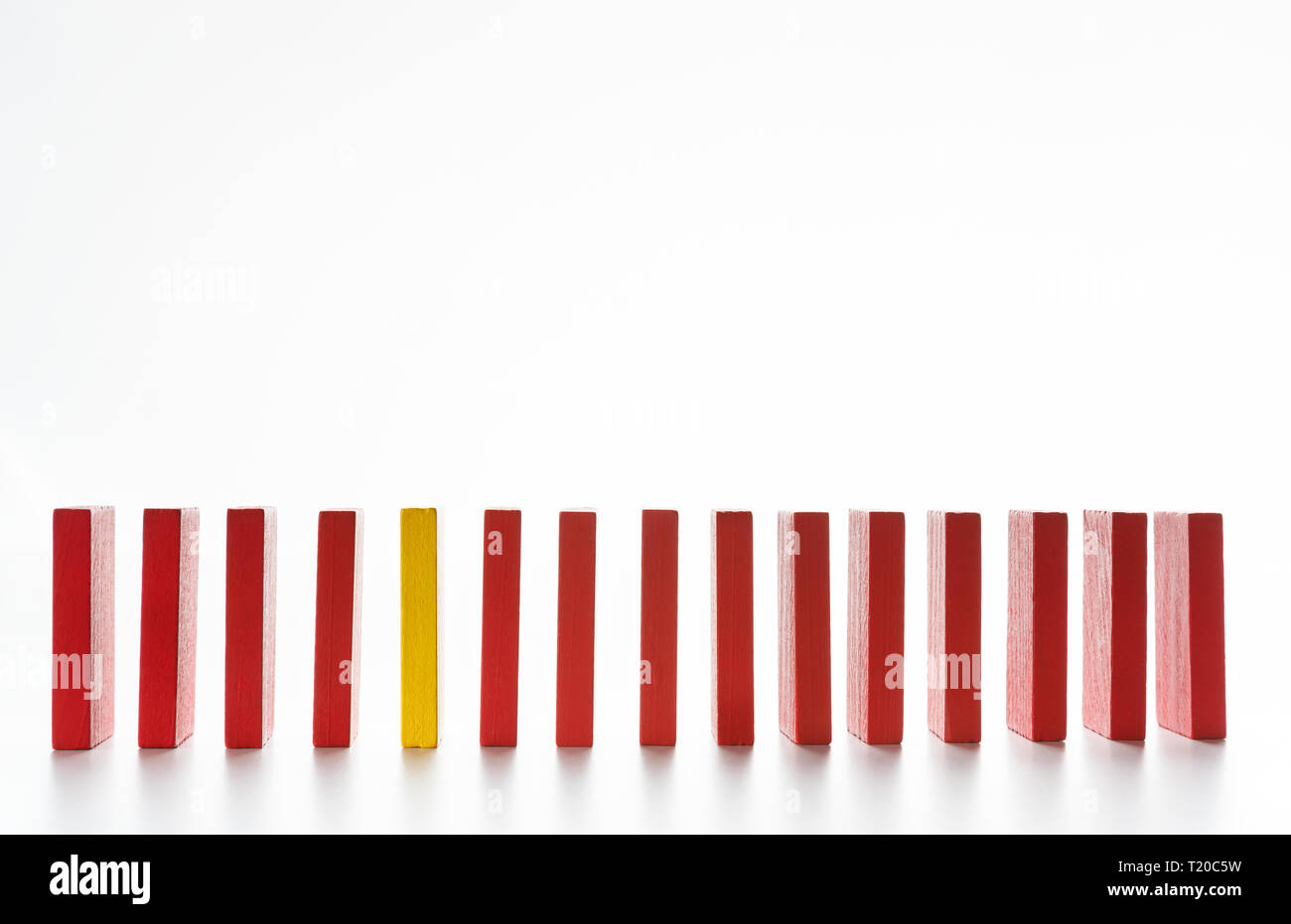 Think different concept. One yellow wooden block standing among red ...
