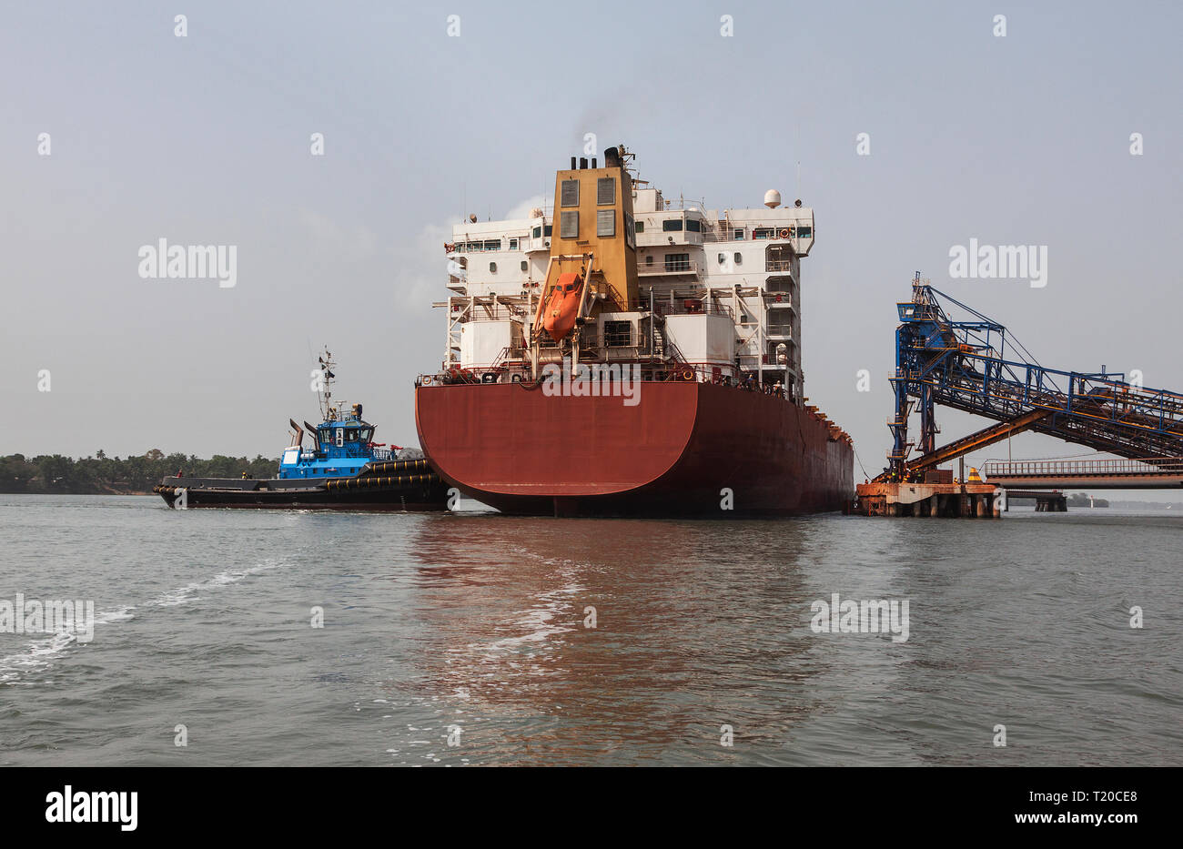 Port operations for managing and transporting iron ore. Tug moving and ...