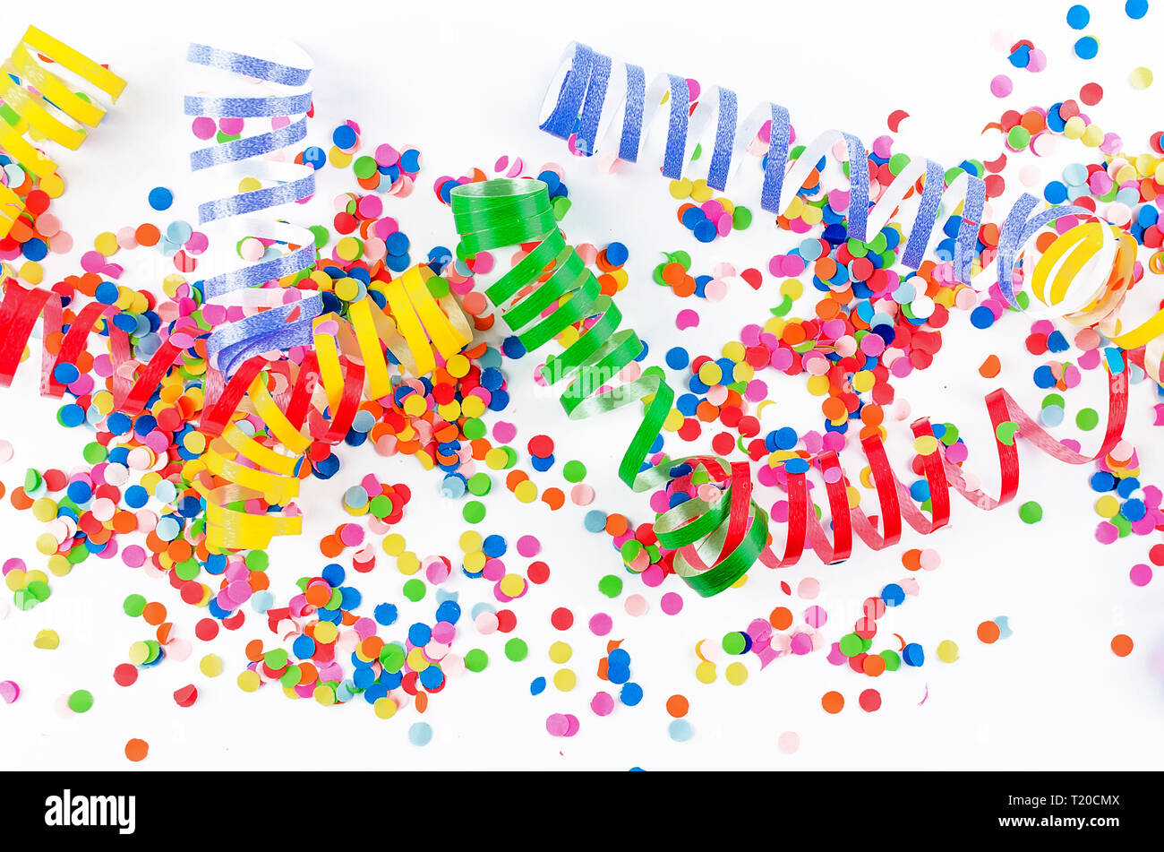 Colorful paper confetti and colored twirled party serpentine on a white ...