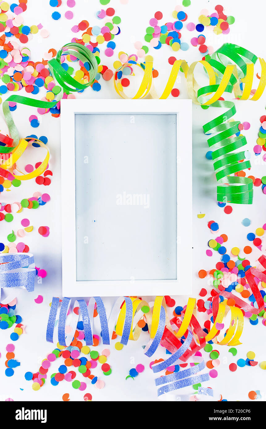 Colorful paper confetti and colored twirled party serpentine on a white ...