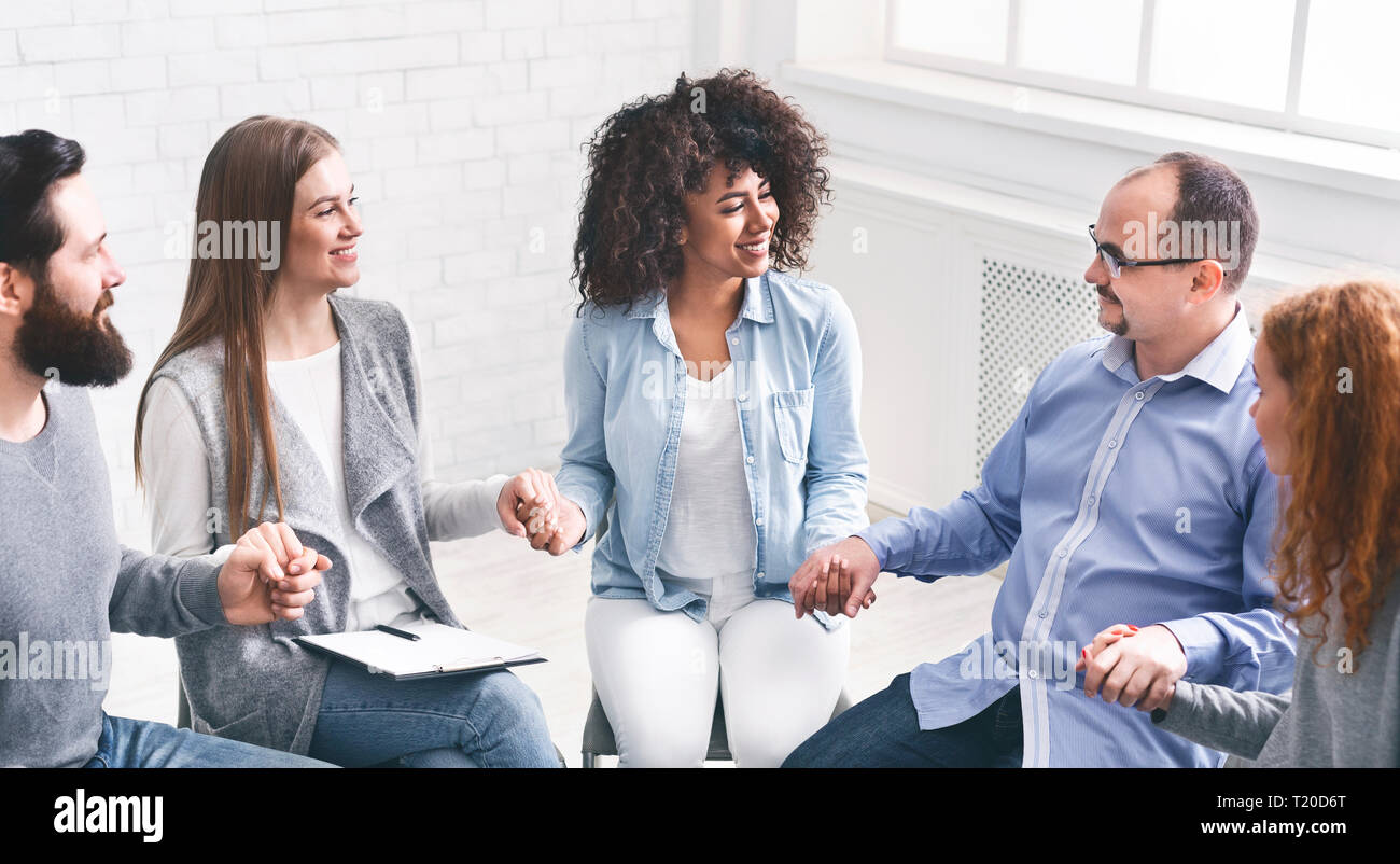 Young people holding hands together during group therapy Stock Photo ...