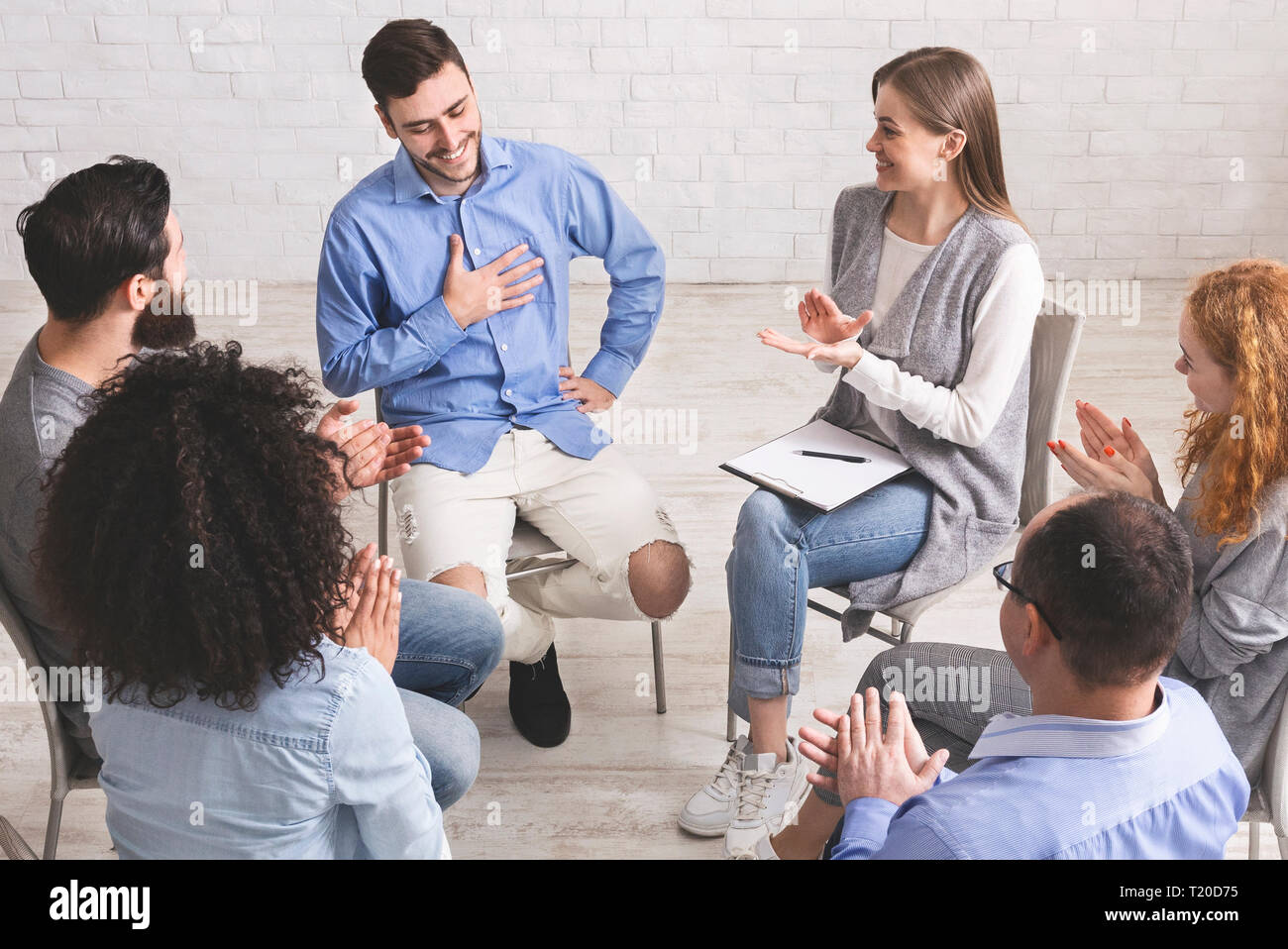 Happy people clapping at support group meeting Stock Photo - Alamy