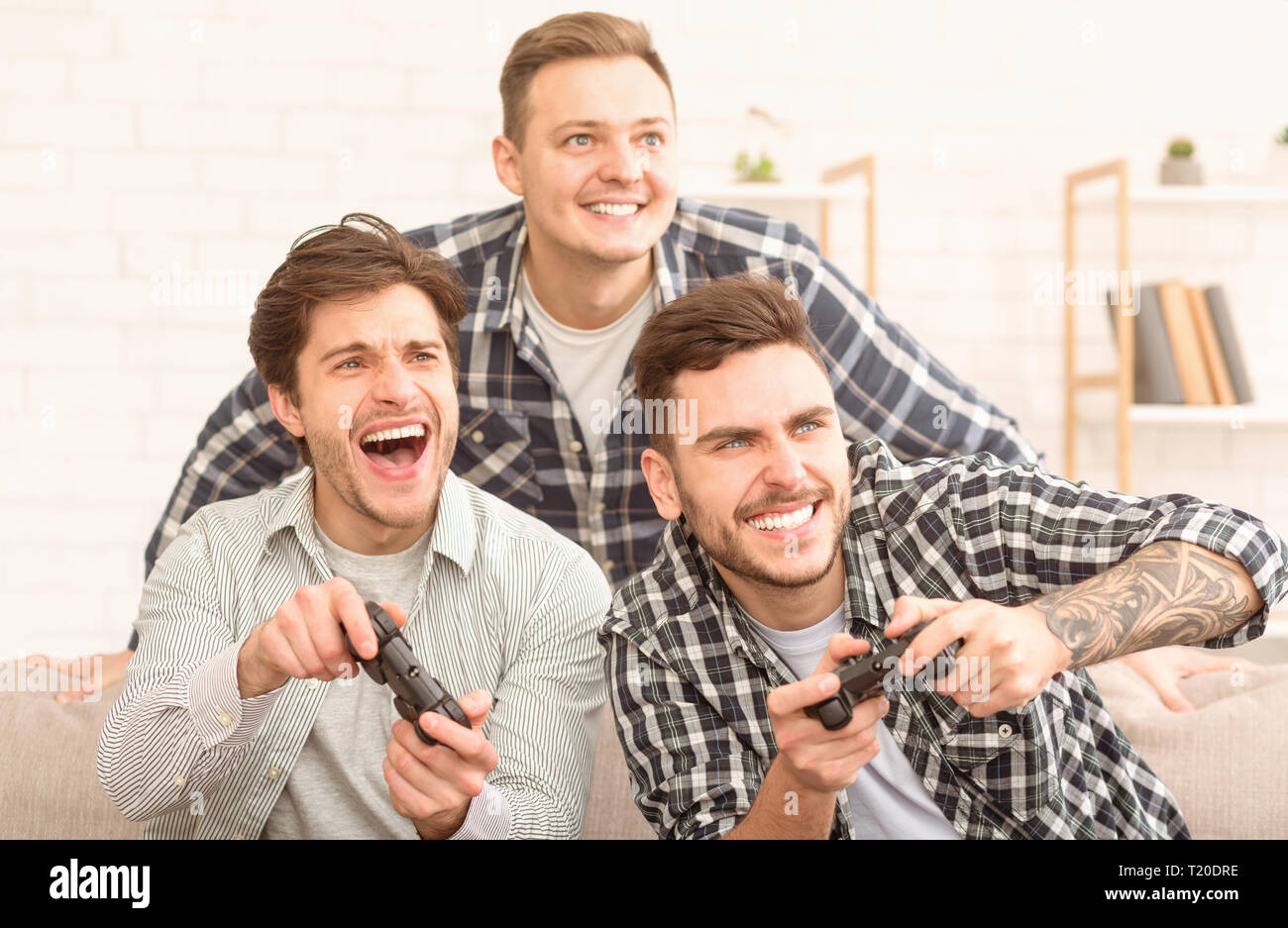 Avid gamers. Excited men playing video game, meeting and having fun at ...