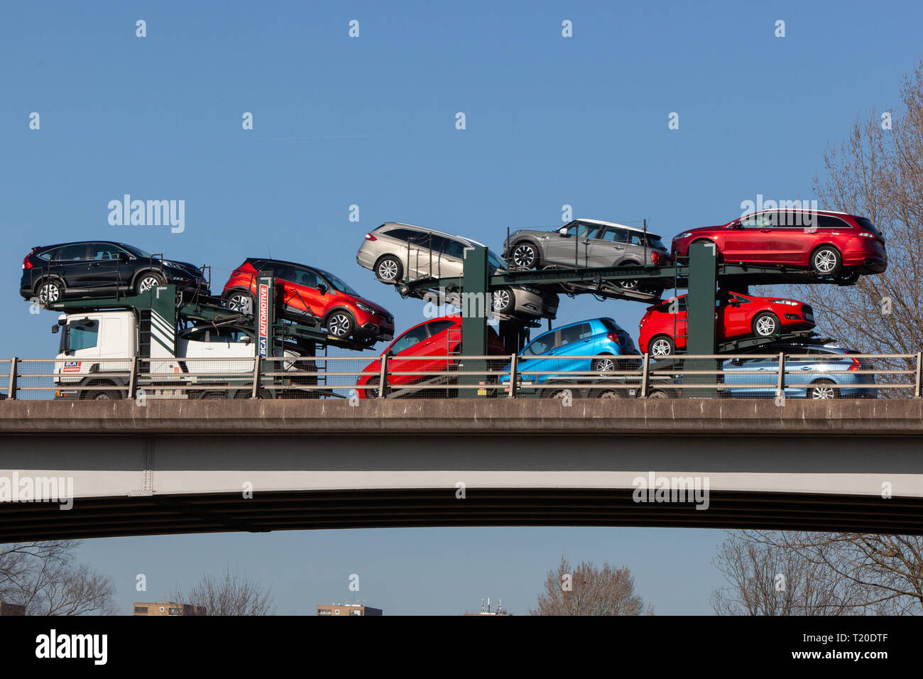Car transporter carrying multiple vehicles. Traveling on the road ...