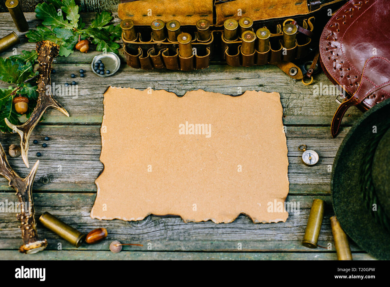 Vintage paper in the center of hunting equipment, oak and horns around ...