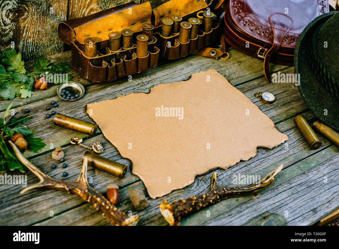 Vintage paper in the center of hunting equipment, oak and horns around ...
