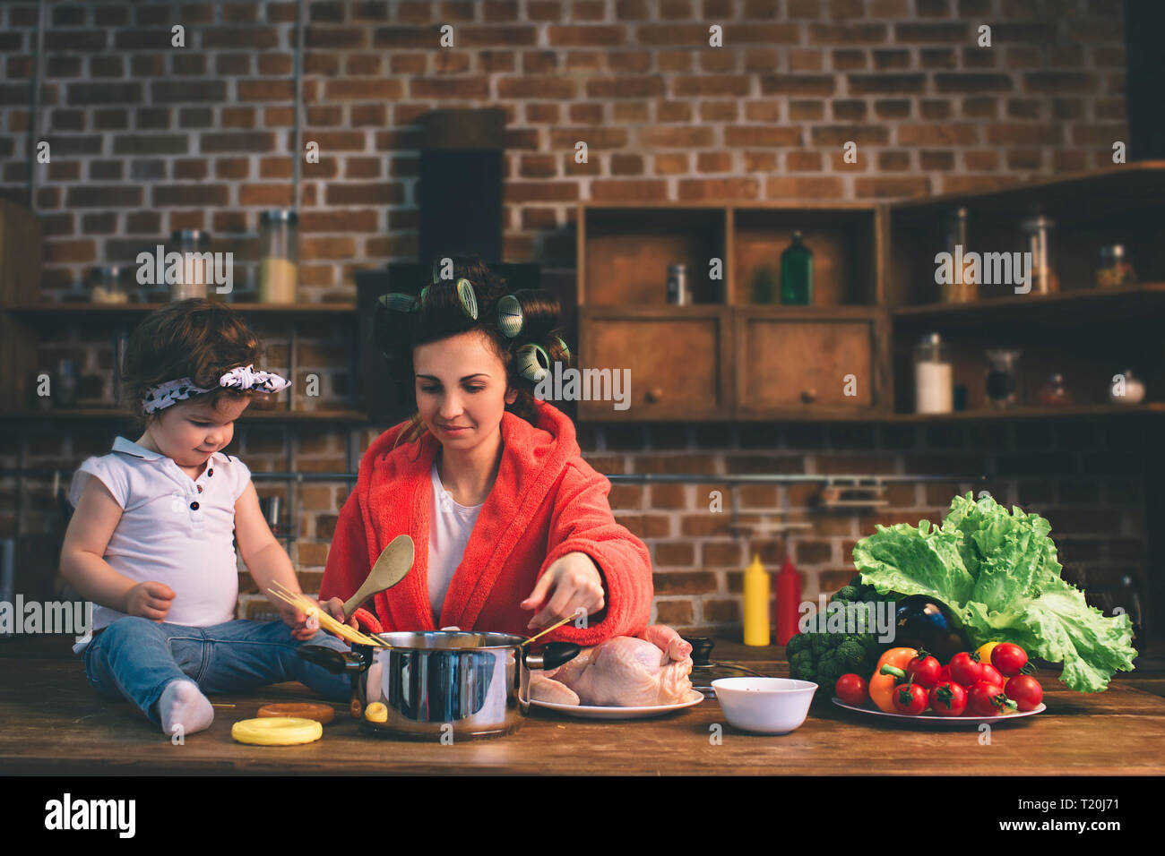 Mum at home. Young mother with little child in the home kitchen. Woman ...