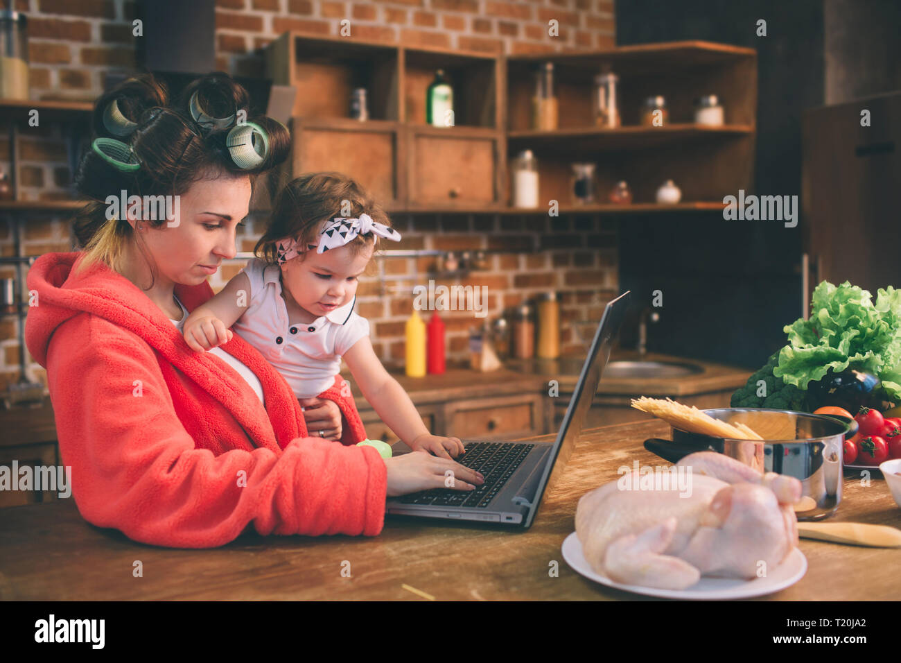 Mum at home. Young mother with little child in the home kitchen. Woman ...
